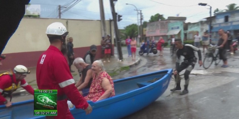 People and rescuers make their way through flooded streets in eastern ...