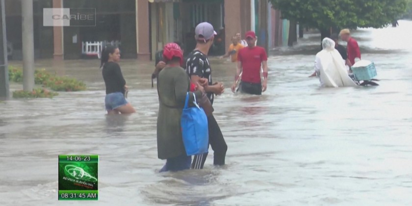 People and rescuers make their way through flooded streets in eastern ...