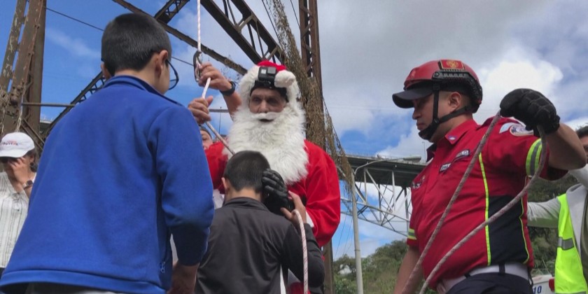 Santa firefighter rappels gifts down a bridge for Guatemalan kids ...